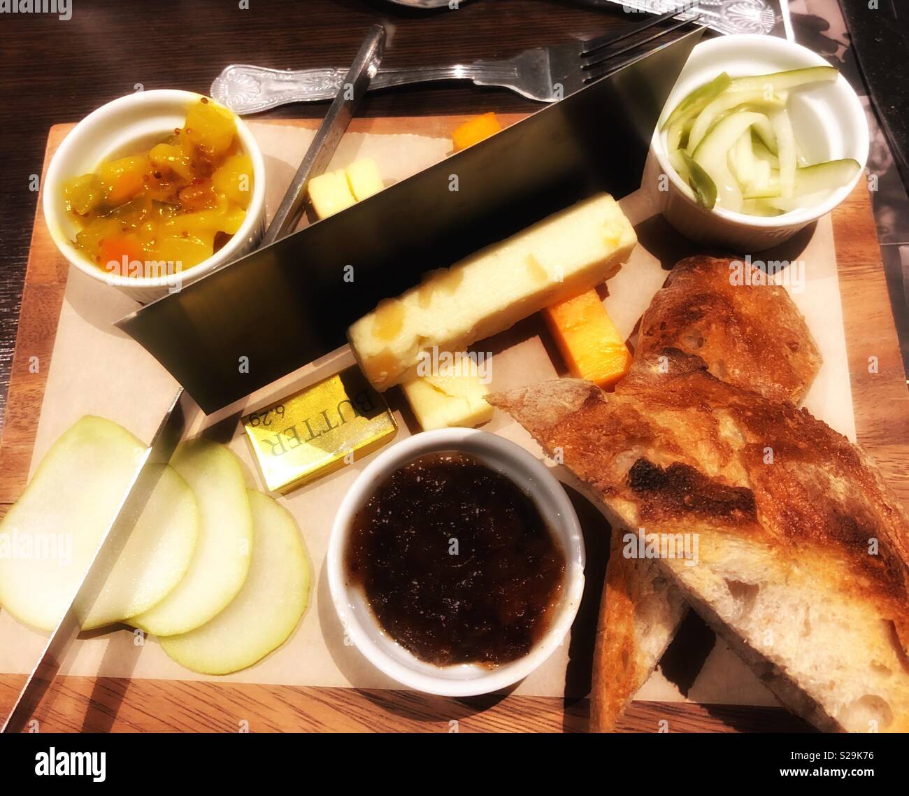 Cheese platter with chutney, pickled, sour dough bread, cucumber and ...