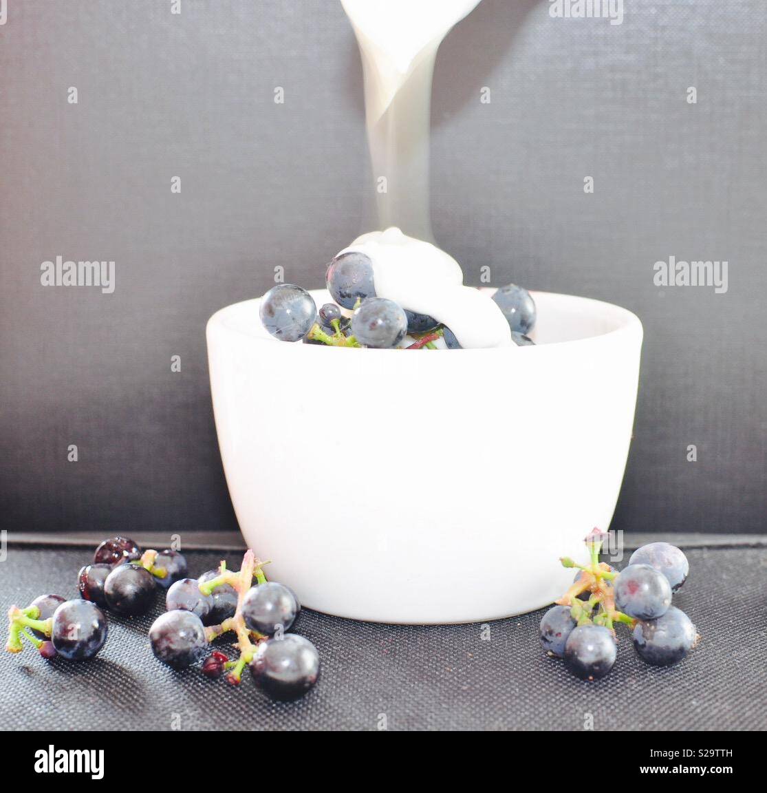 Grapes with pouring yoghurt Stock Photo - Alamy