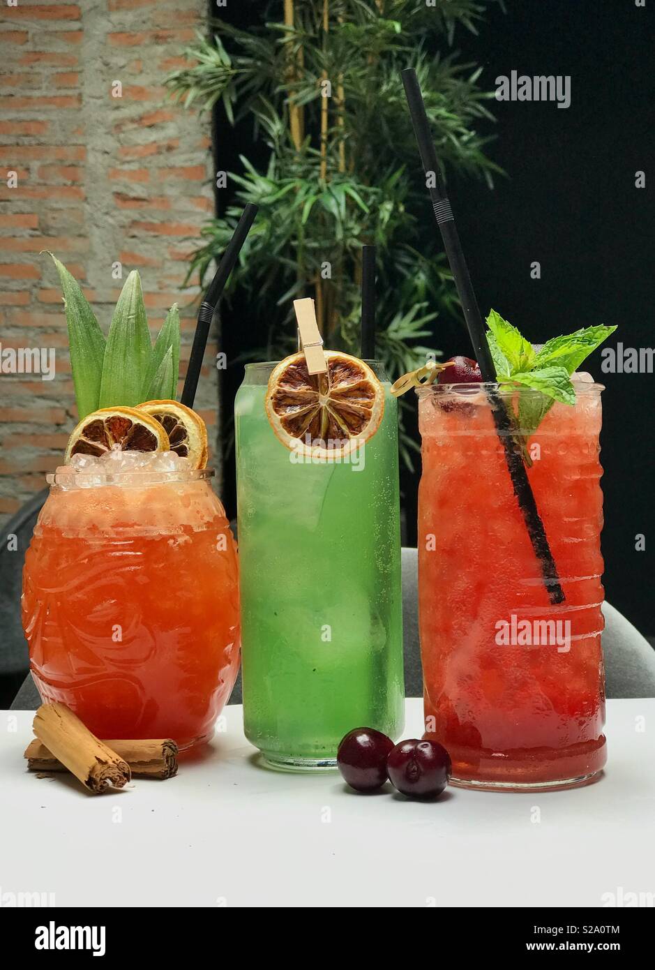 Professional cocktails decorated with lemon, cinnamon and cherries ...