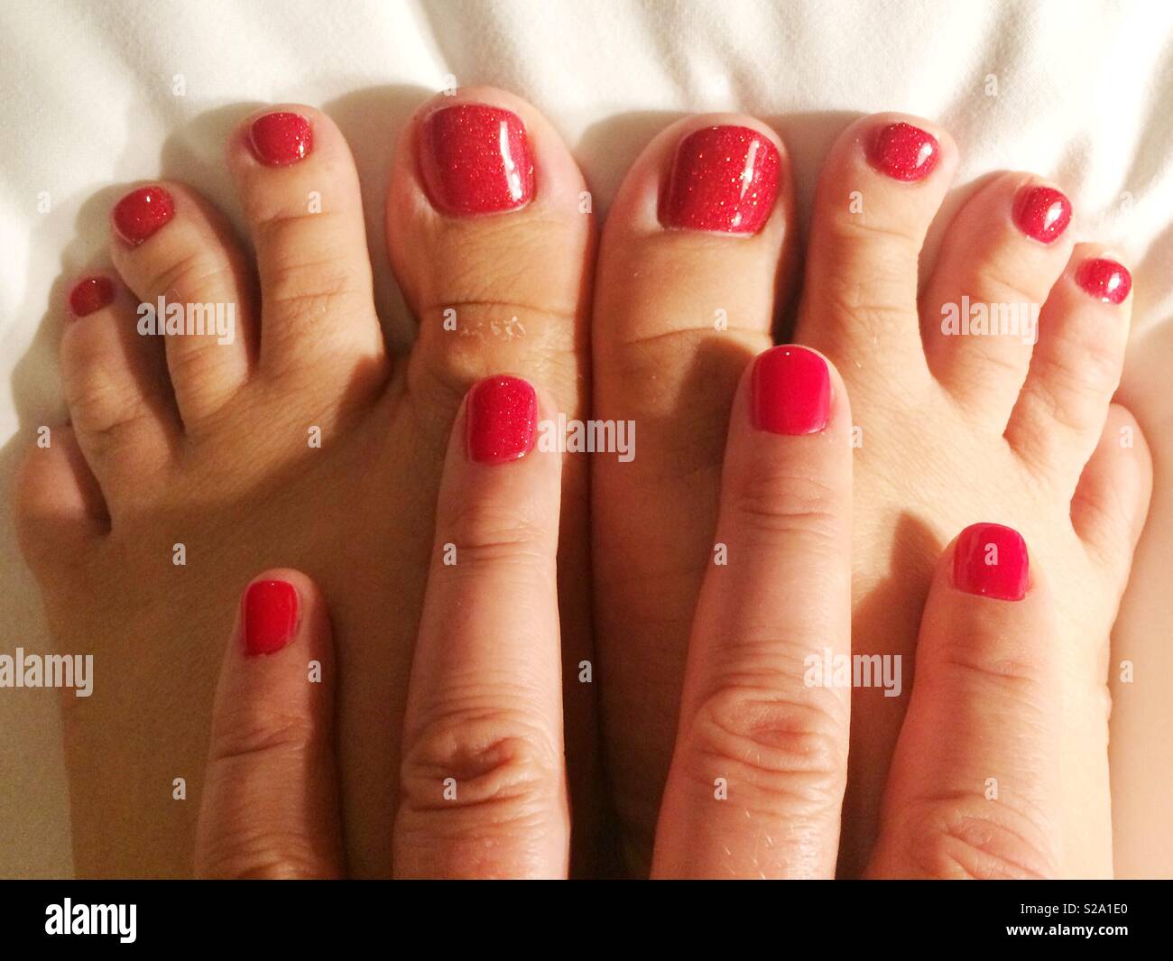 Hand and feet with coordinated red nail polish Stock Photo - Alamy