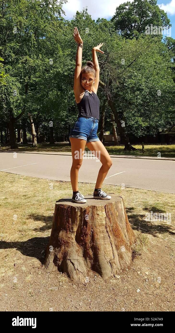 Girl on a tree stump Stock Photo - Alamy