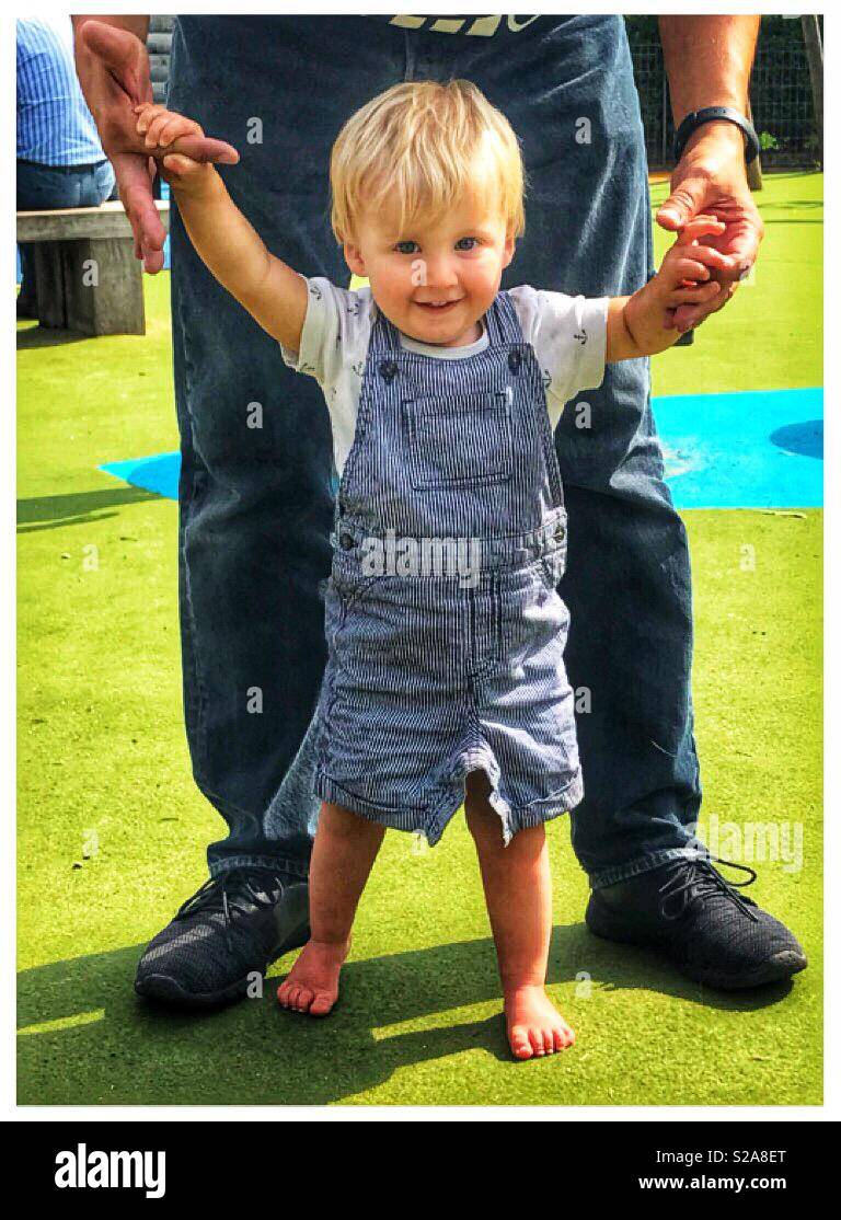 Little boy taking his first steps Stock Photo - Alamy