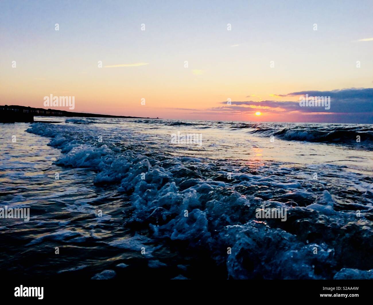 Breaking surf, sunset, empty beach, perfect day Stock Photo - Alamy