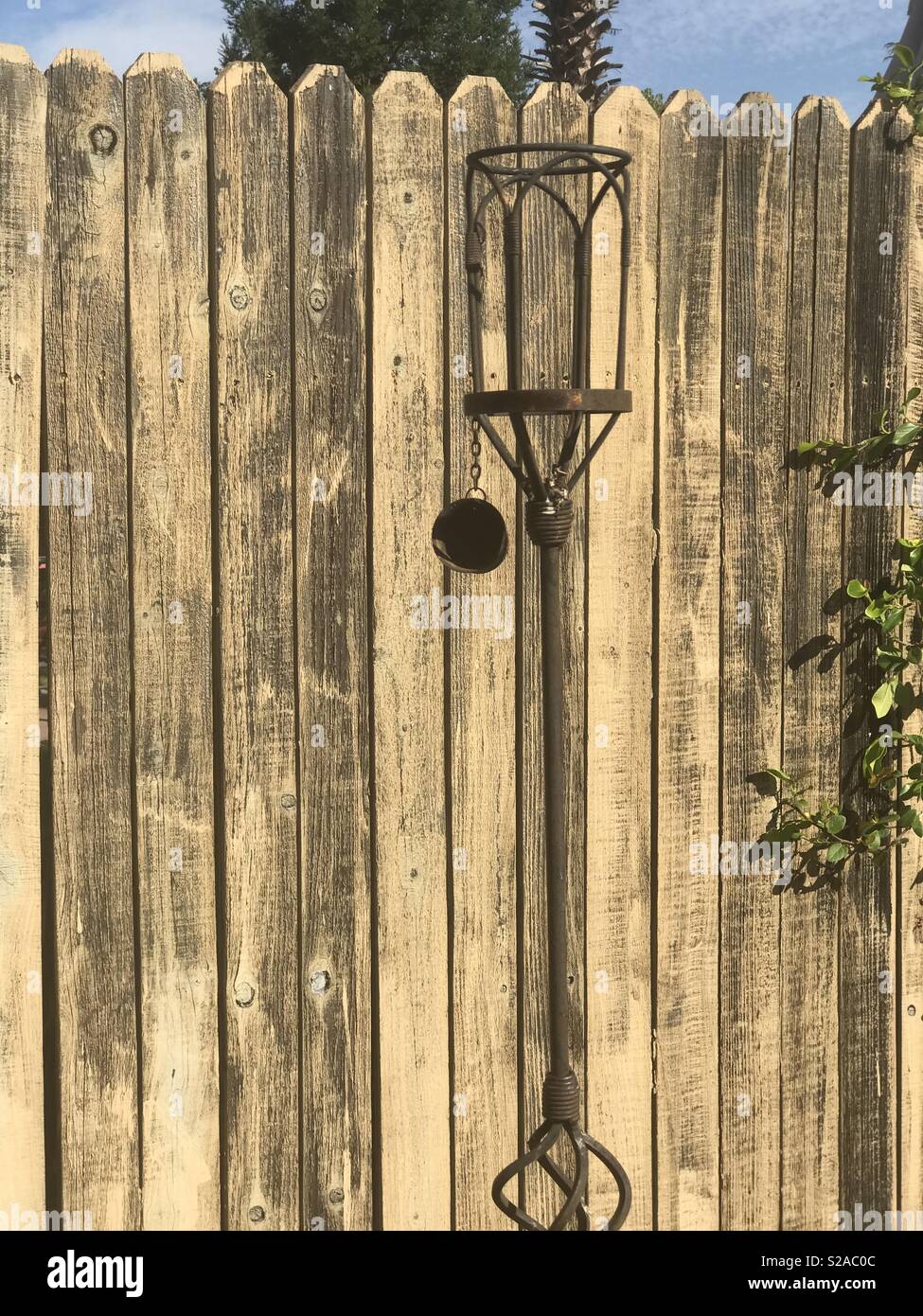 Colorful golden outdoor tiki lamp in the back yard in front of a golden ...