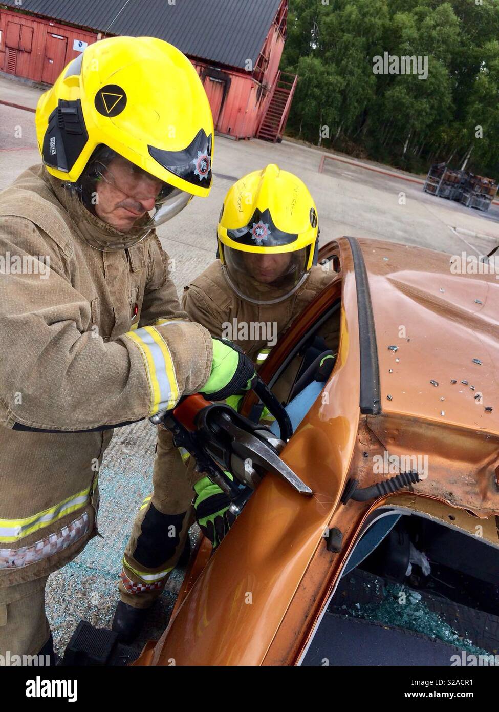 Firemen cutting car Stock Photo - Alamy