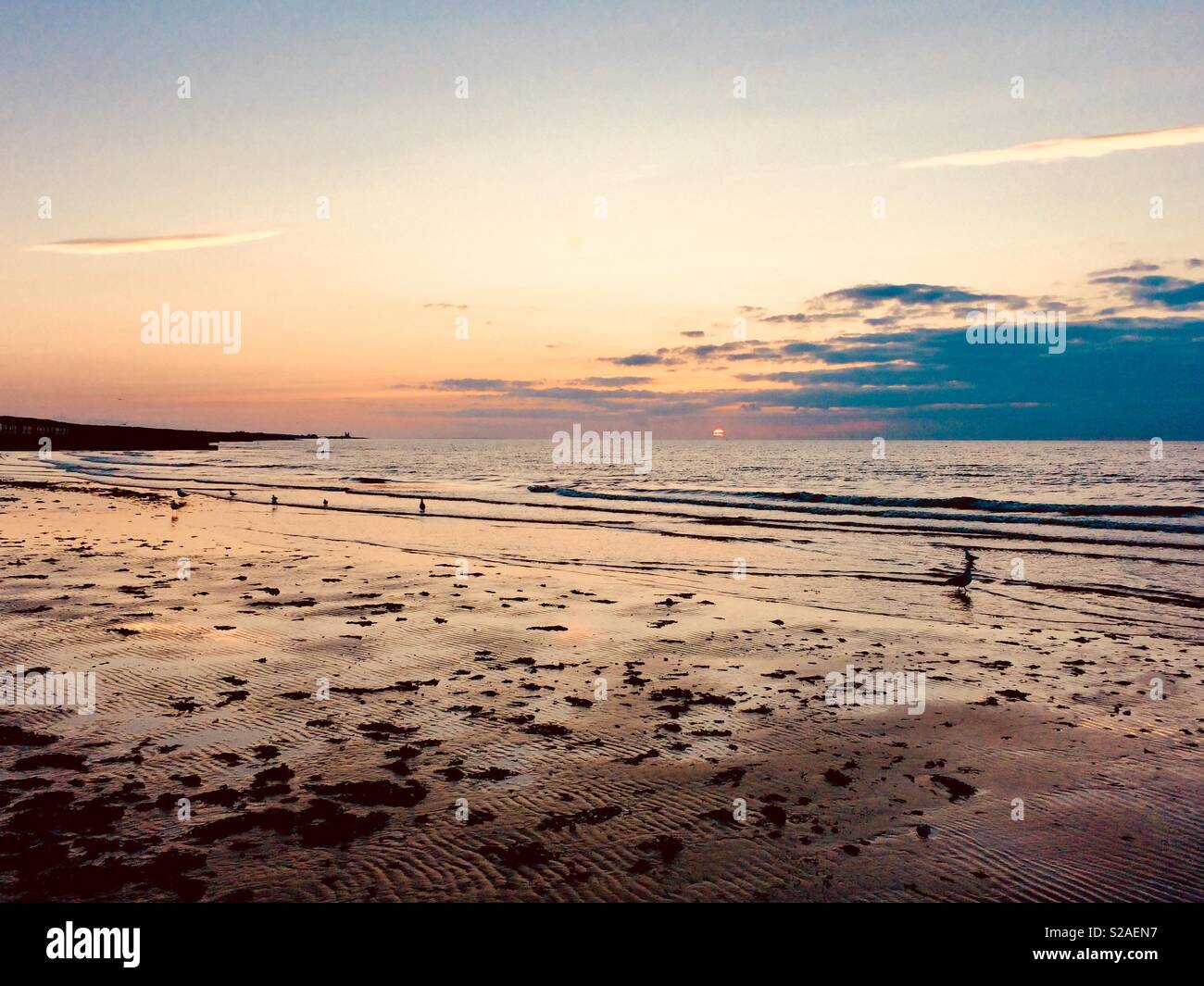 Tide going out during summer sunset Stock Photo - Alamy