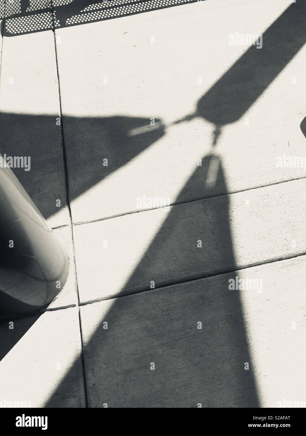 Abstract Art of Dark, hard shadows on the cement ground at the park ...
