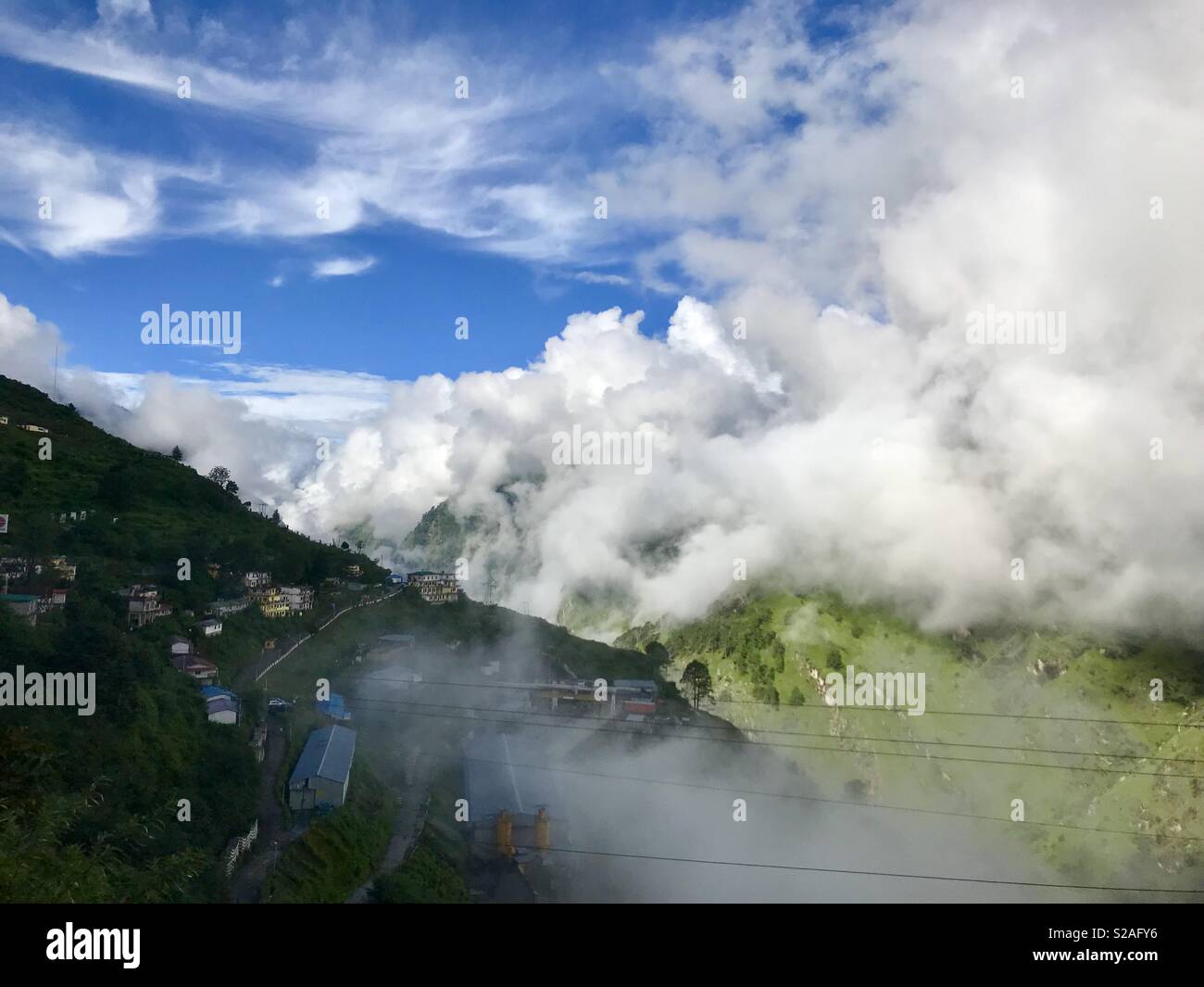 Hillside village and clouds Stock Photo - Alamy