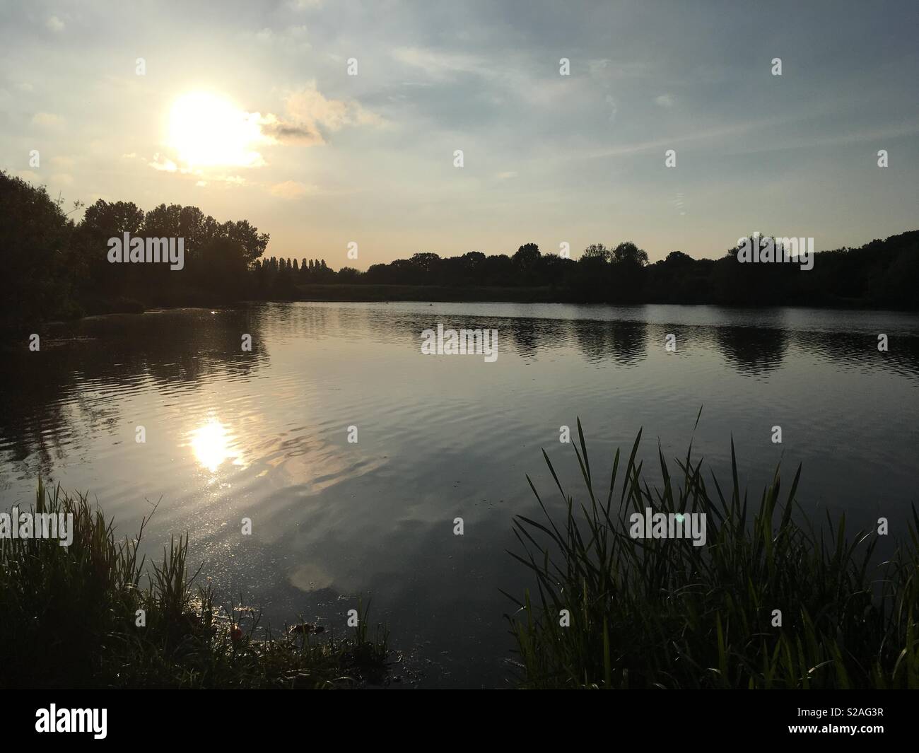 Sun Setting over Lake Stock Photo - Alamy