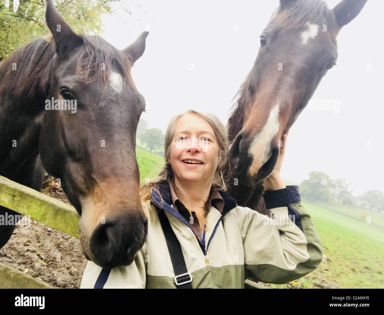 A smiling women with two horses Stock Photo - Alamy