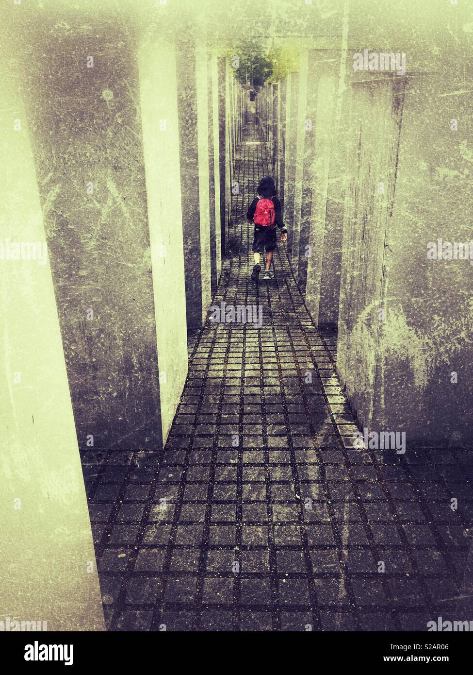 8 years child walking the narrow path with red bag on his back Stock ...