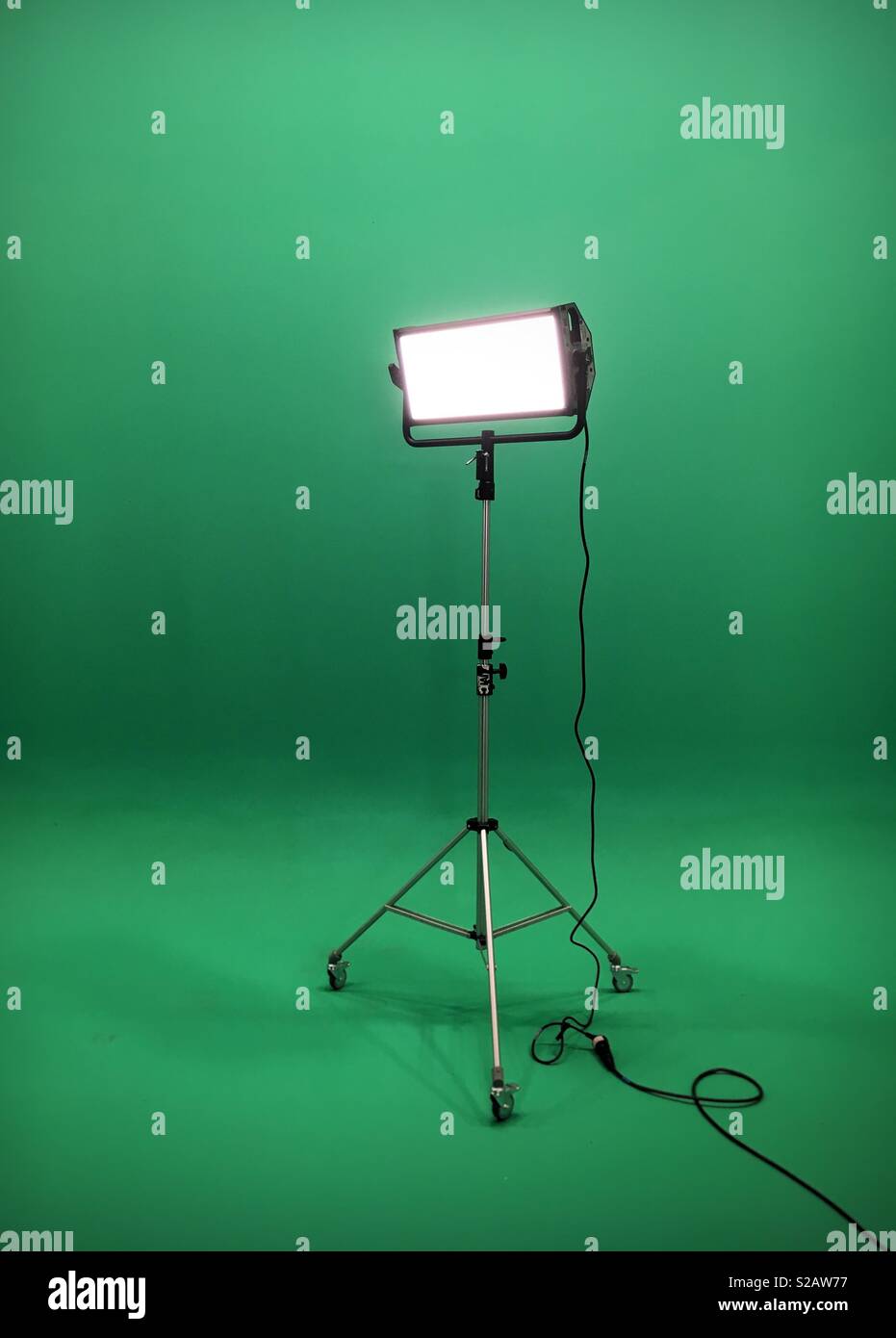 Led light on tripod in green key studio Stock Photo - Alamy