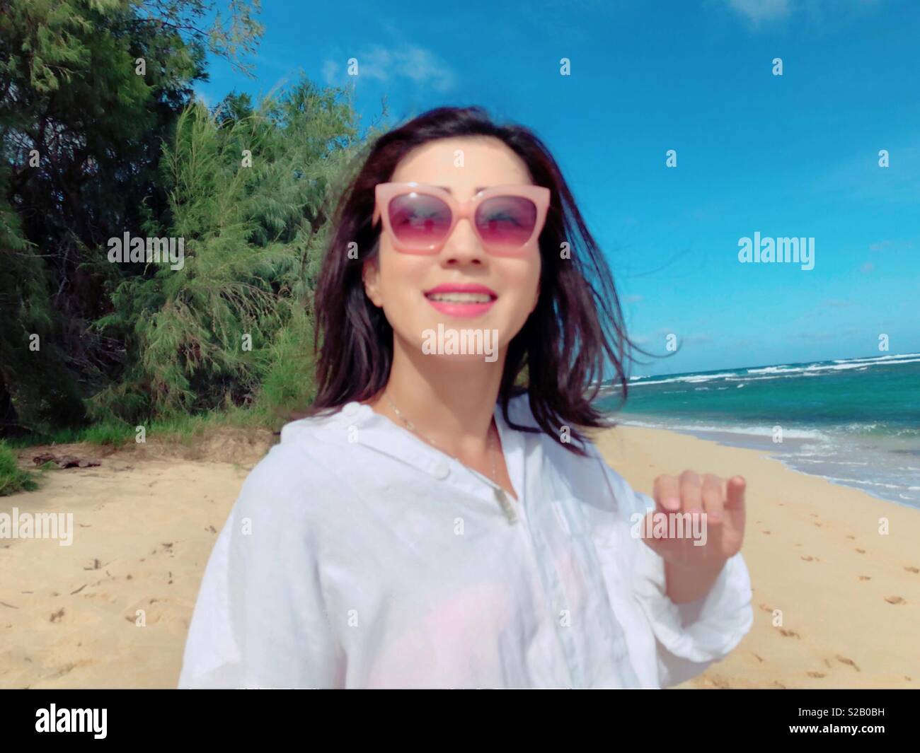 Beautiful young Asian woman in retro pink sunglasses and white linen ...