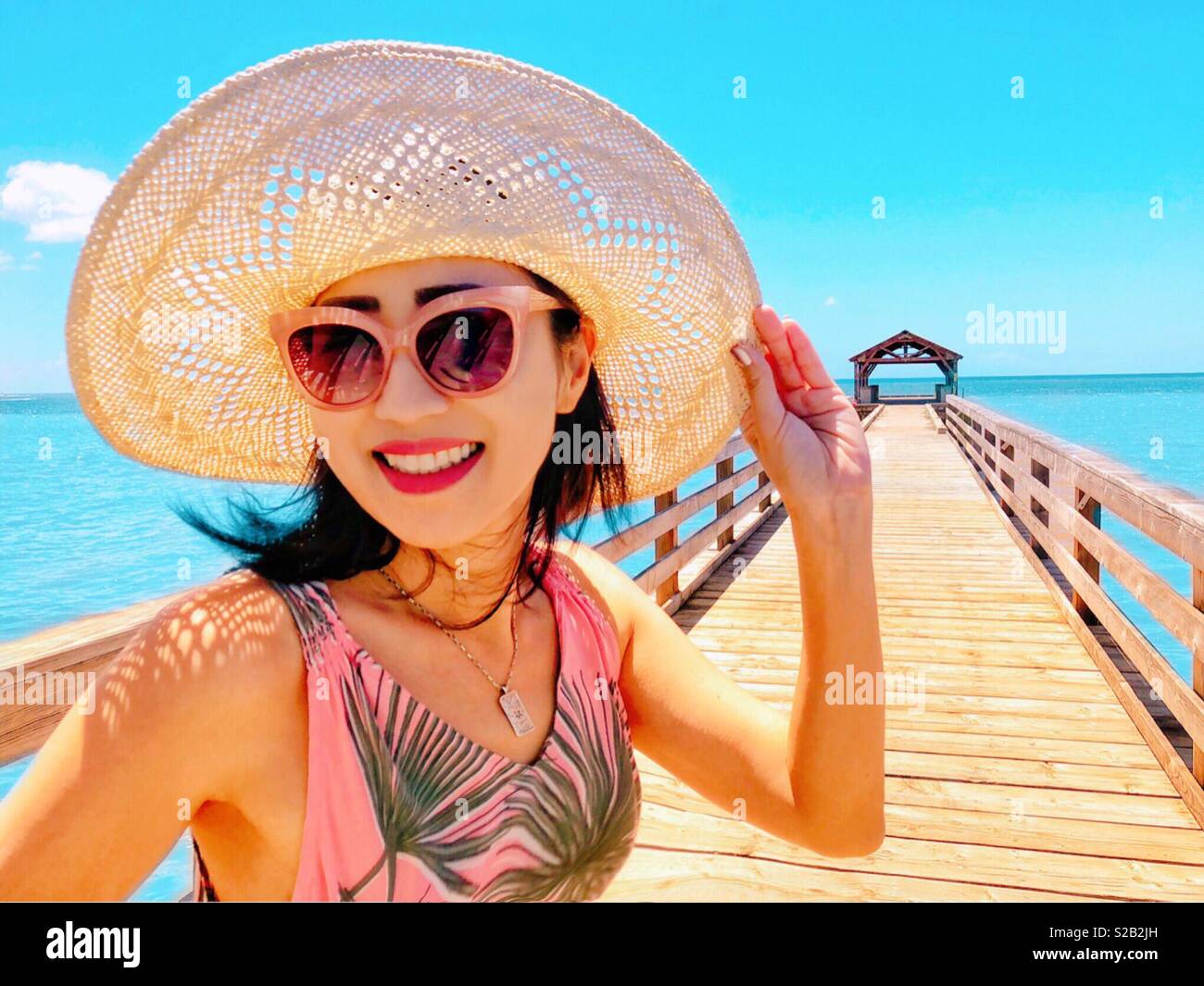 Beautiful young brunette woman with shapely figure, long floral pink ...