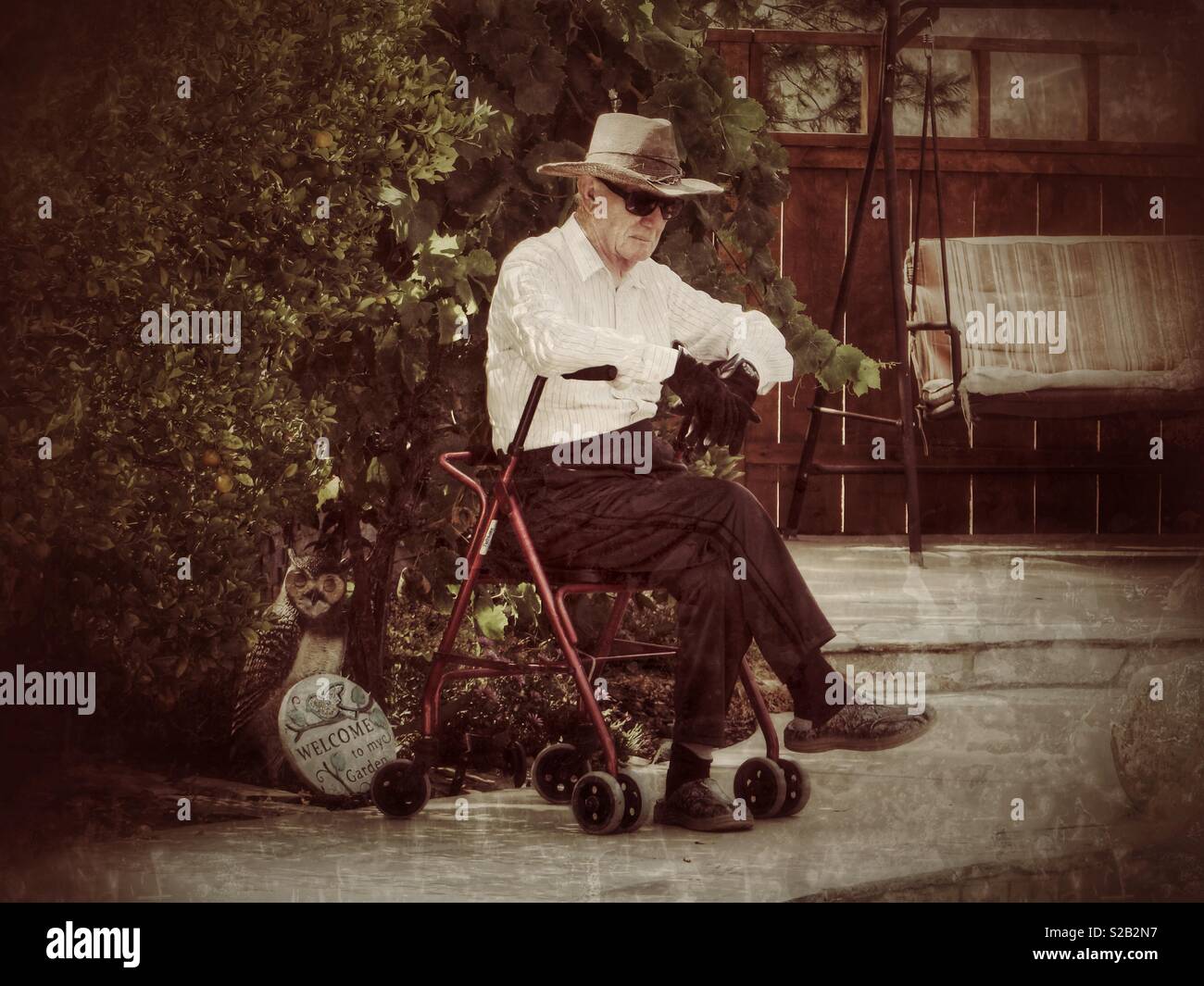 Elderly man sitting on a walker Stock Photo - Alamy