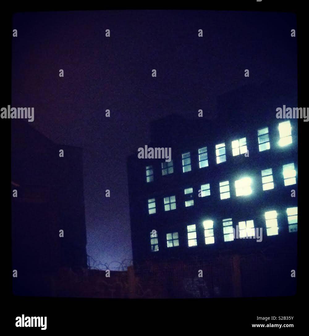 Industrial building late at night lit up Stock Photo - Alamy