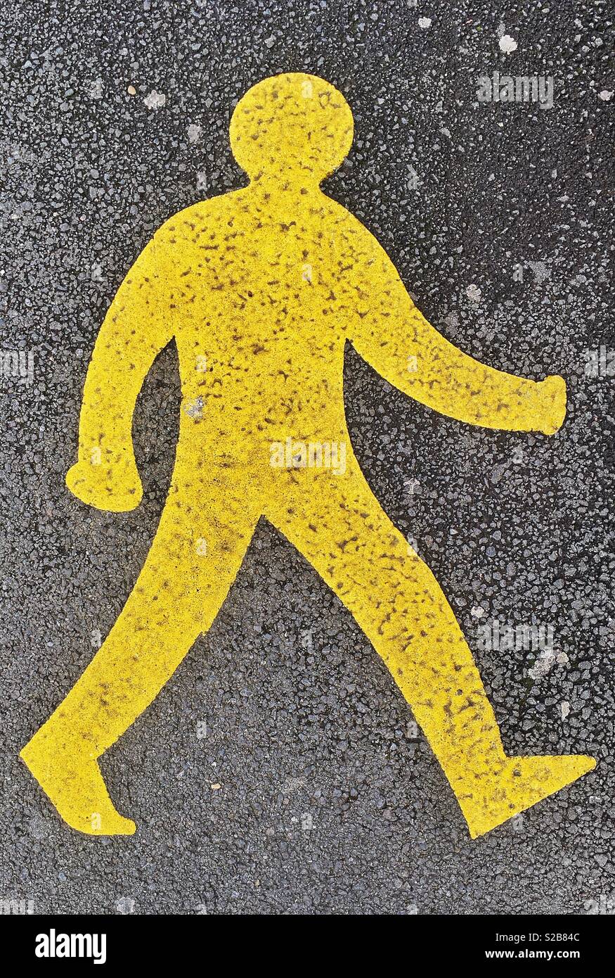 A figure of a walking man painted on a pavement to give directions to ...