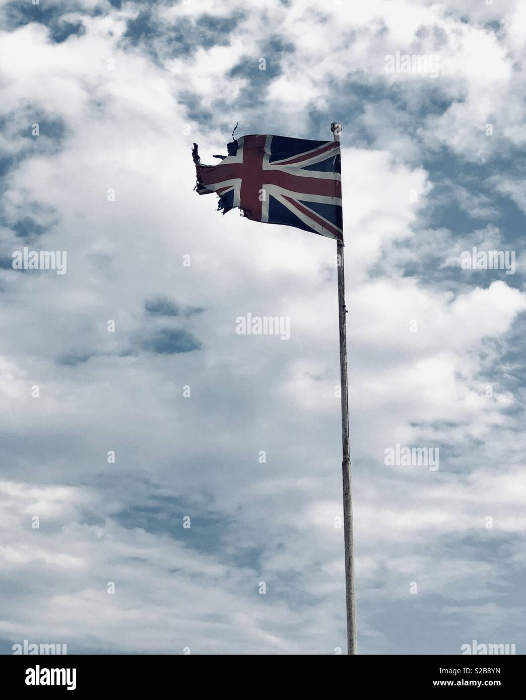 An old half destroyed Union Jack flag flapping in the wind Stock Photo ...