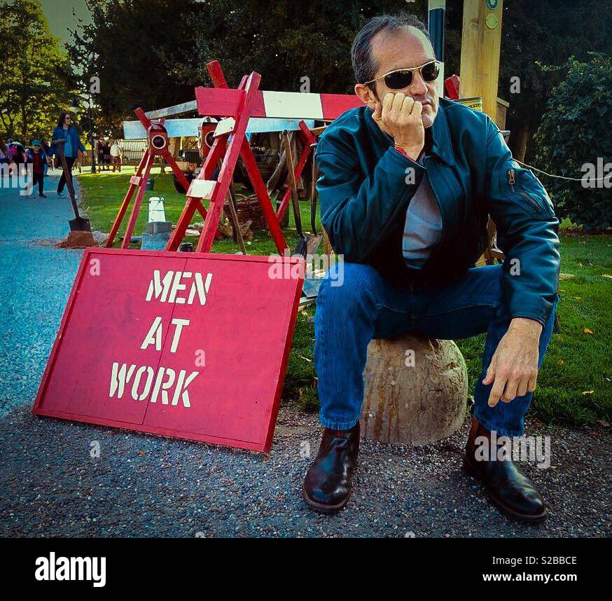 Man Thinking In Front Of Men At Work Sign Stock Photo - Alamy