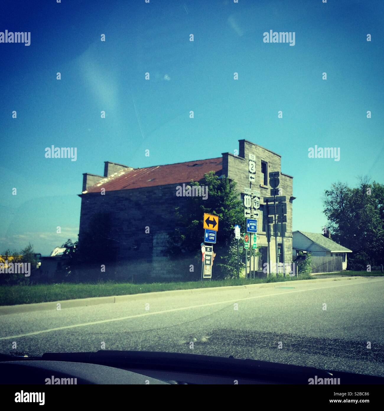 Old building and road signs Aden while driving near Rouse’s Point, New ...