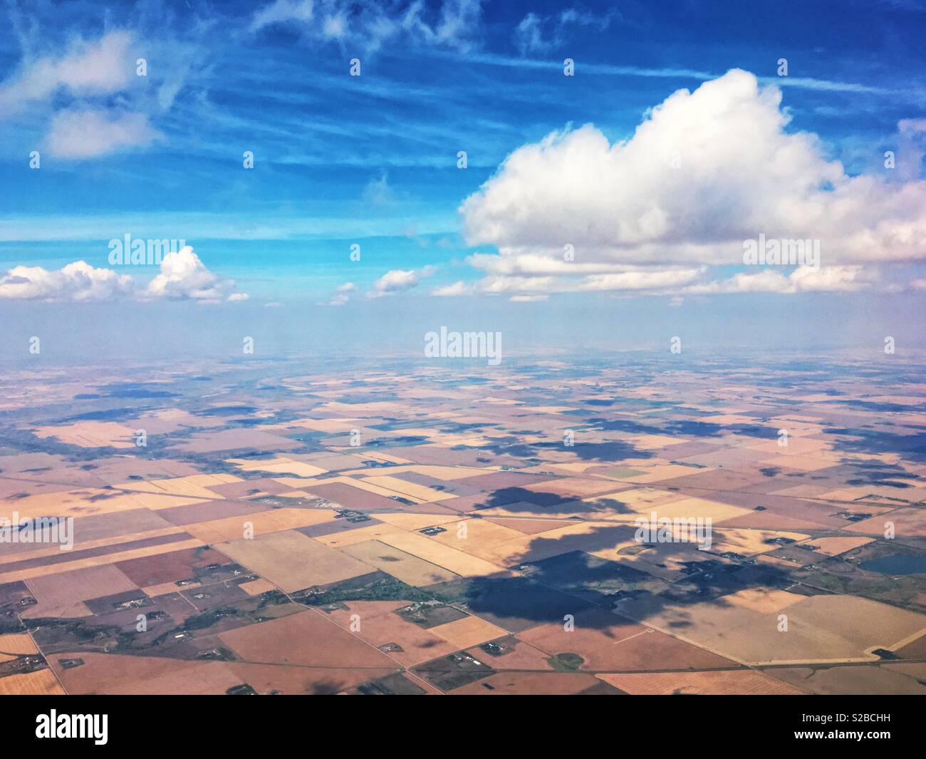 Areal view of farms under a blue a September sky, with white clouds ...