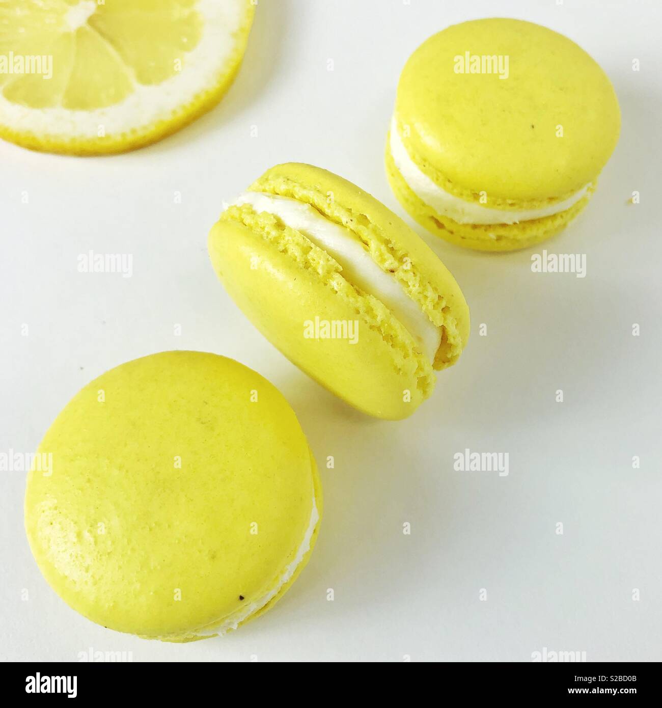 Bright Yellow lemon meringue macaroons and lemon slice on white ...