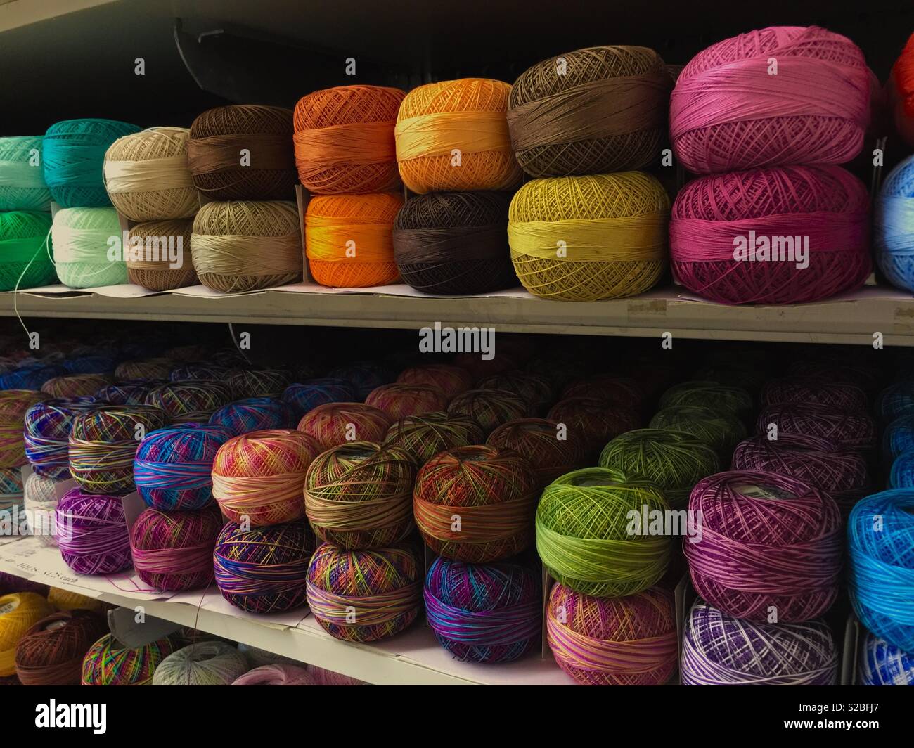 Colorful rolls of string on shelves Stock Photo - Alamy