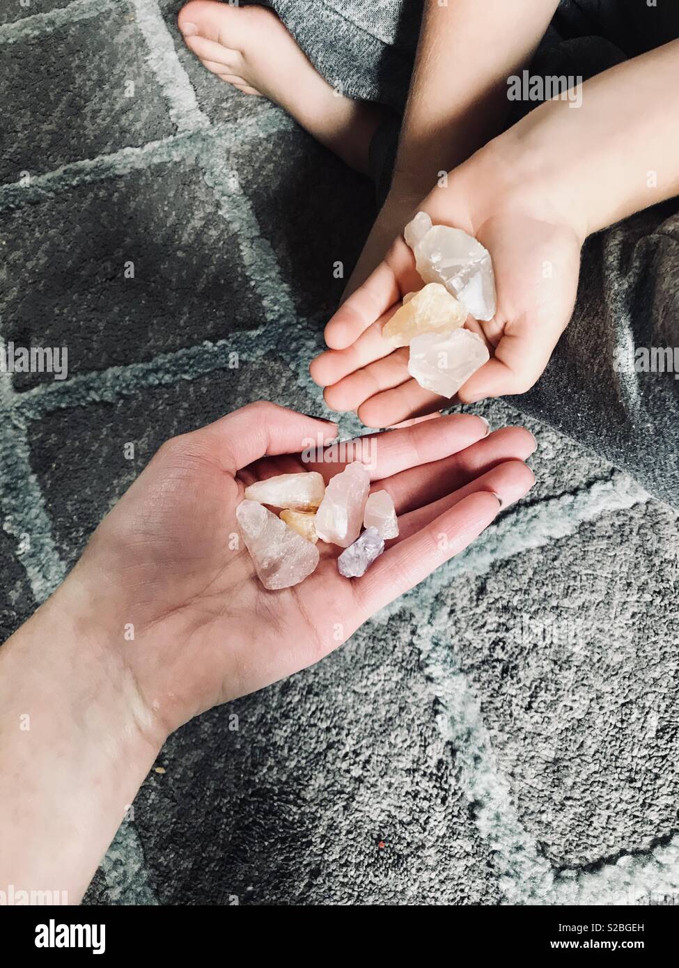 Mother and son holding colorful gem stone crystal quarts rocks in their ...