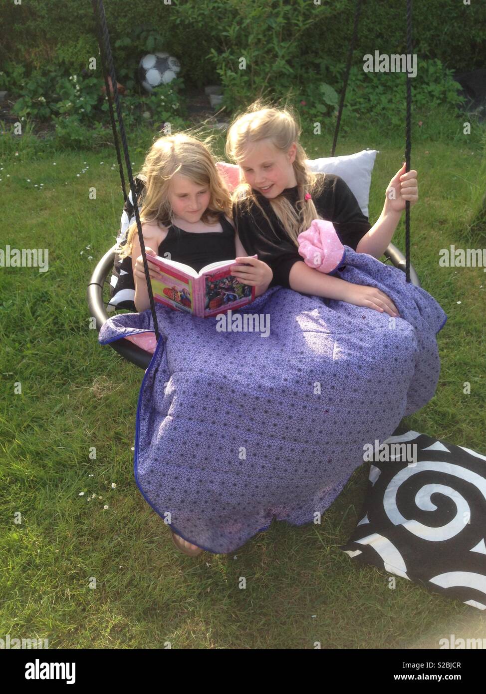 Kids reading in a swing Stock Photo - Alamy