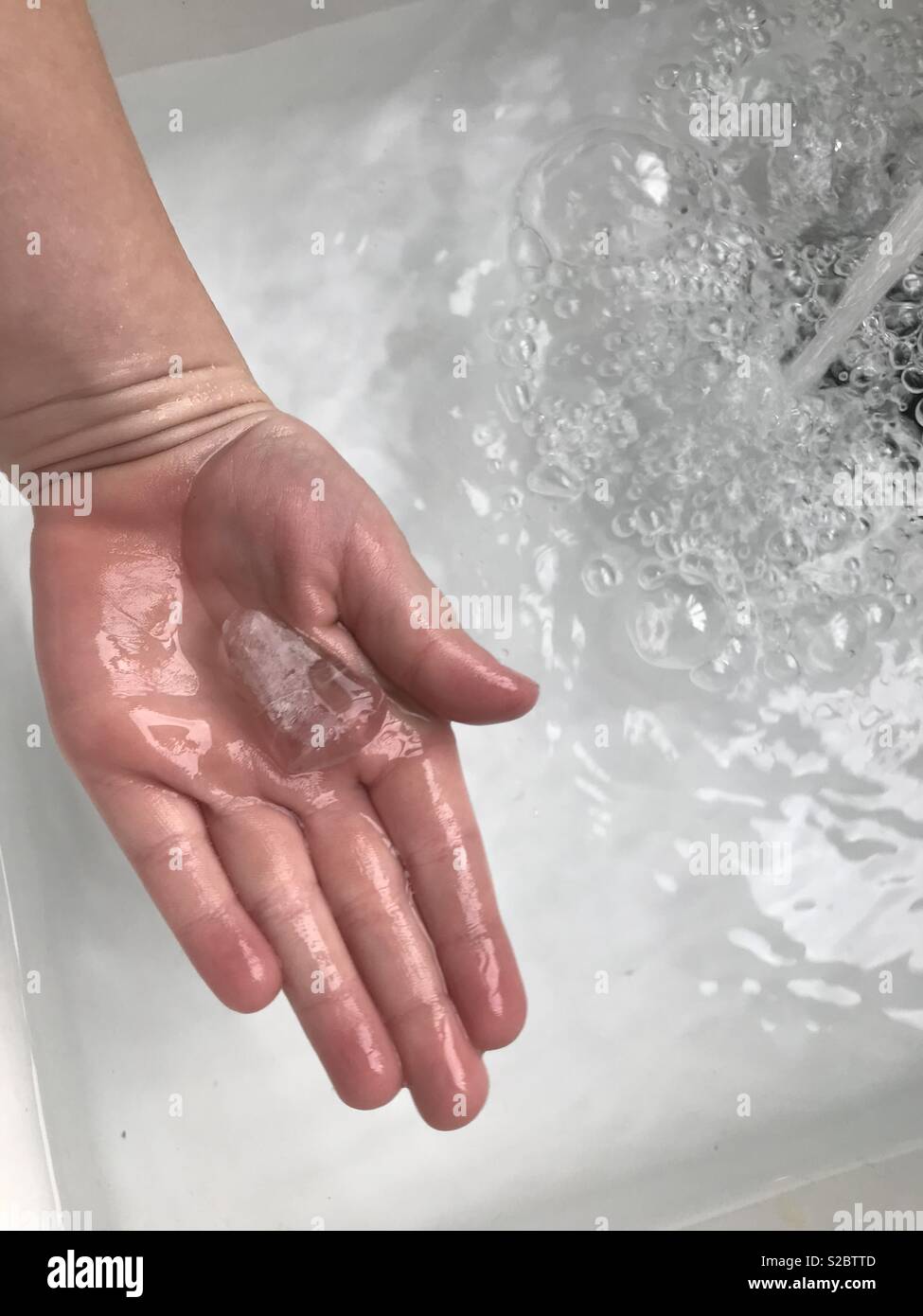 Child washing a quarts gemstone rock in the sink Stock Photo - Alamy