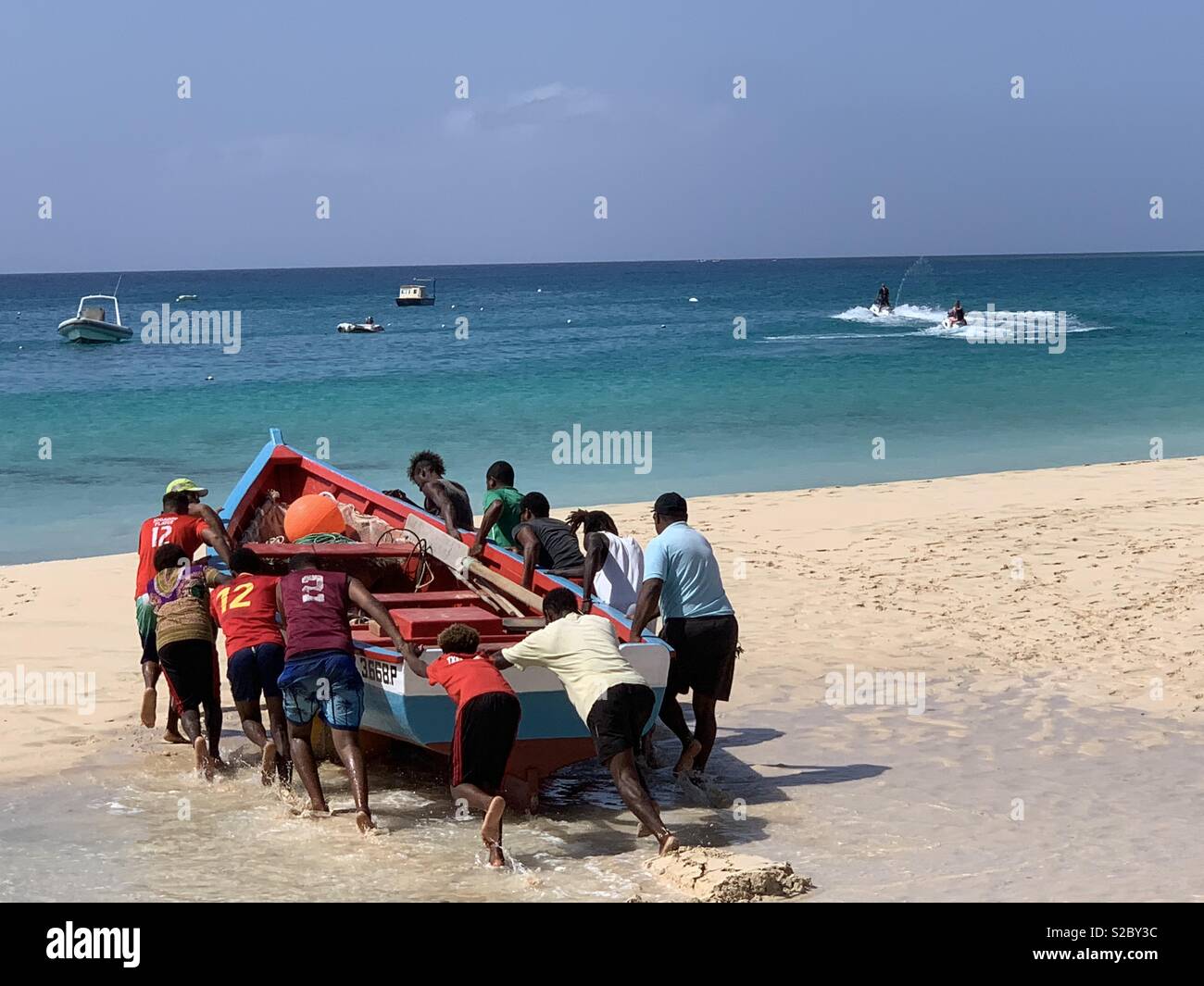 Fisherman setting sail from the beach Stock Photo - Alamy