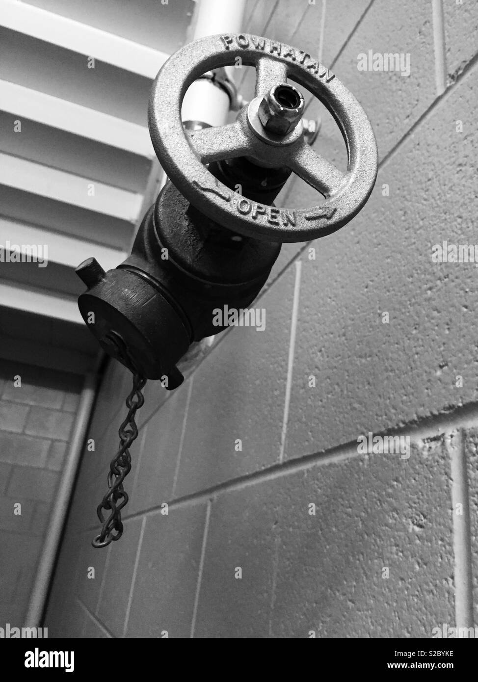black and white valve behind stairwell in brick building Stock Photo ...