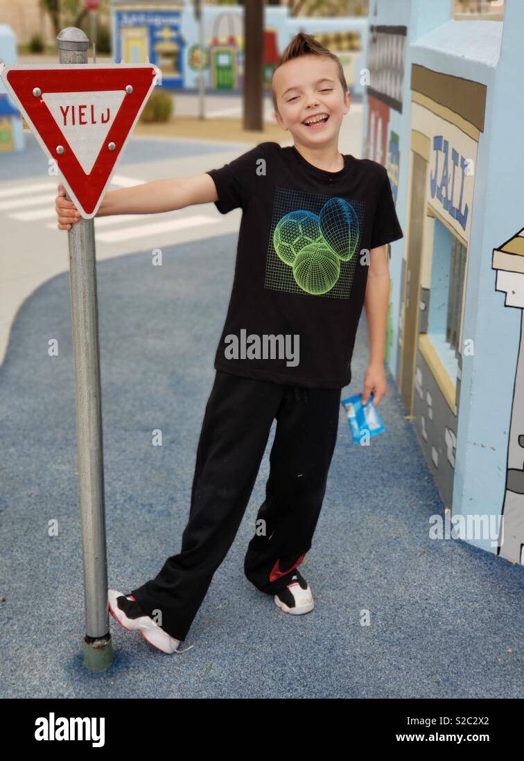 Child,Boy holding yield sign.Kid playing in mock house community Stock ...