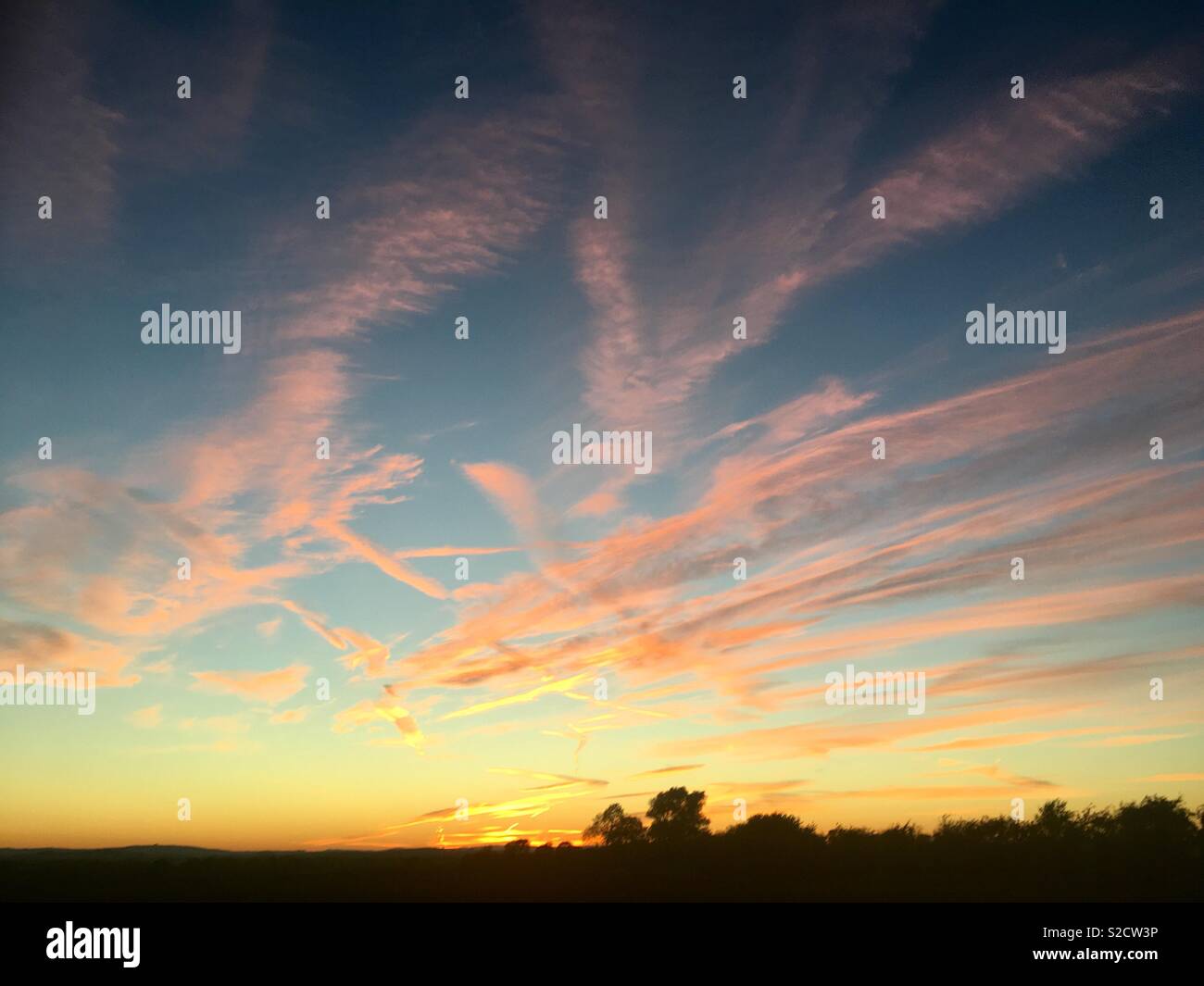 Sunset streaks in blue sky Stock Photo - Alamy