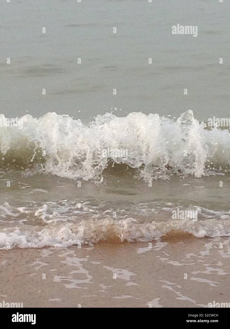 Waves lazily reaching the beach Stock Photo - Alamy