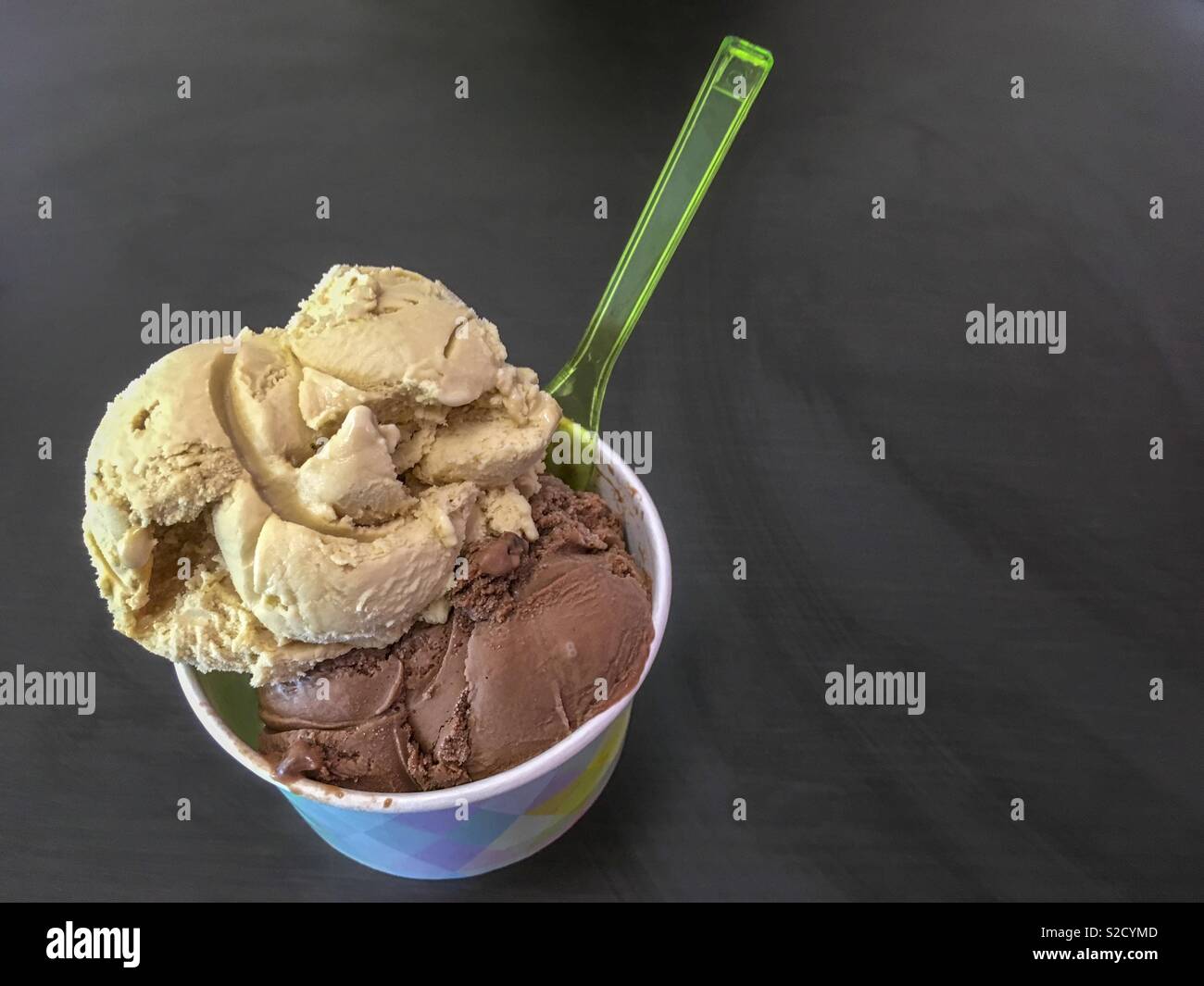 Two scopes of ice cream in a disposable cup and a plastic spoon Stock ...