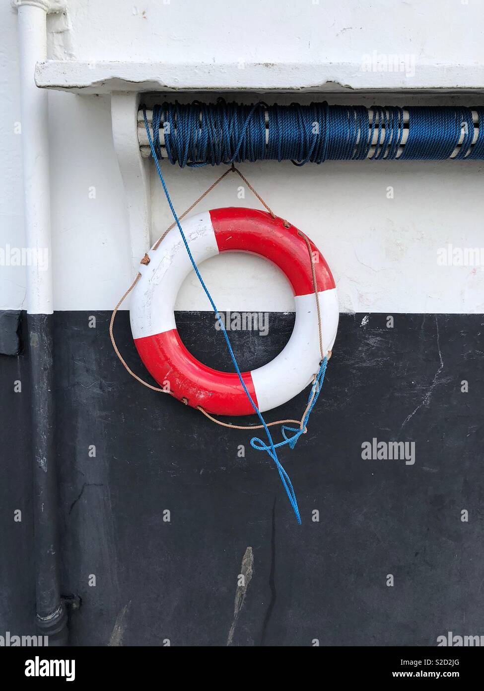 Red and white life preserver with rope attached Stock Photo - Alamy