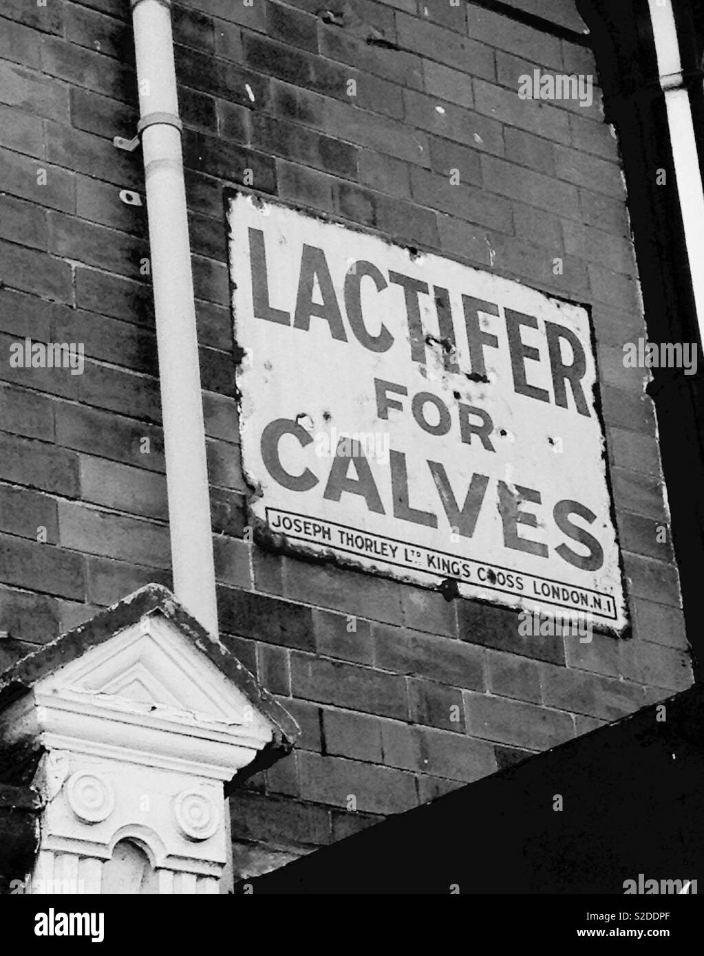 Old metal advertising sign for calf feed seen on a building in a ...