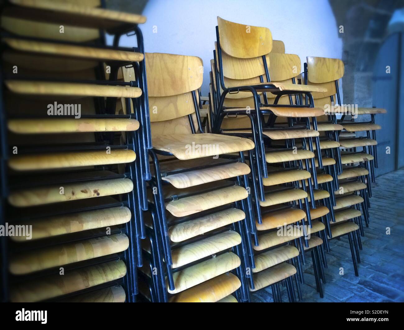 Piles of stacking chairs unsused before an event Stock Photo - Alamy