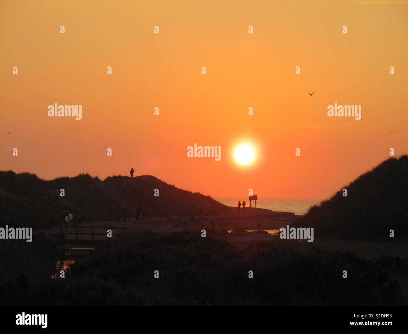 Sunset at gwithian, Cornwall, a national trust beach, this orange sun ...