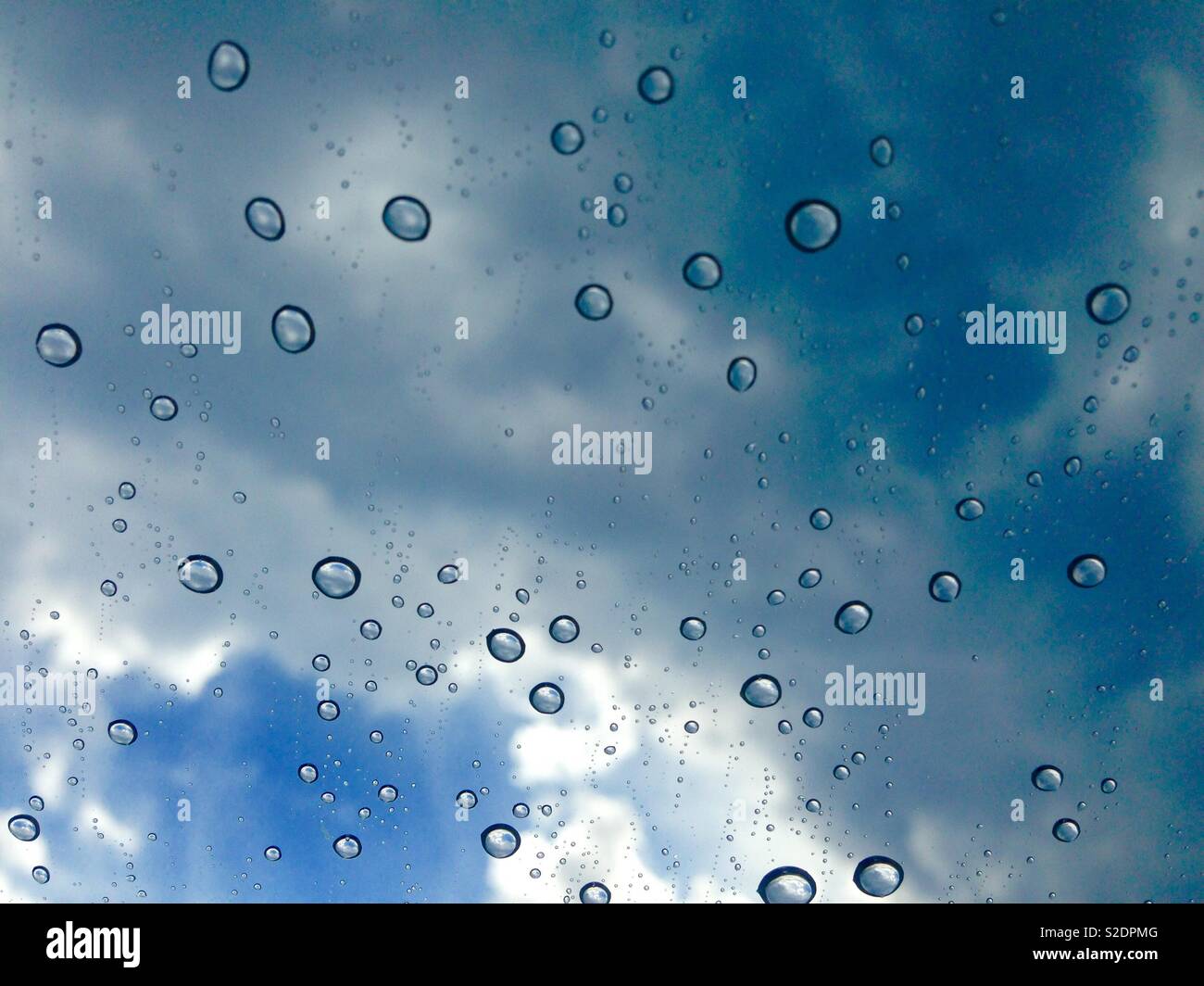 Water droplets on window with clouds and sky in background Stock Photo ...