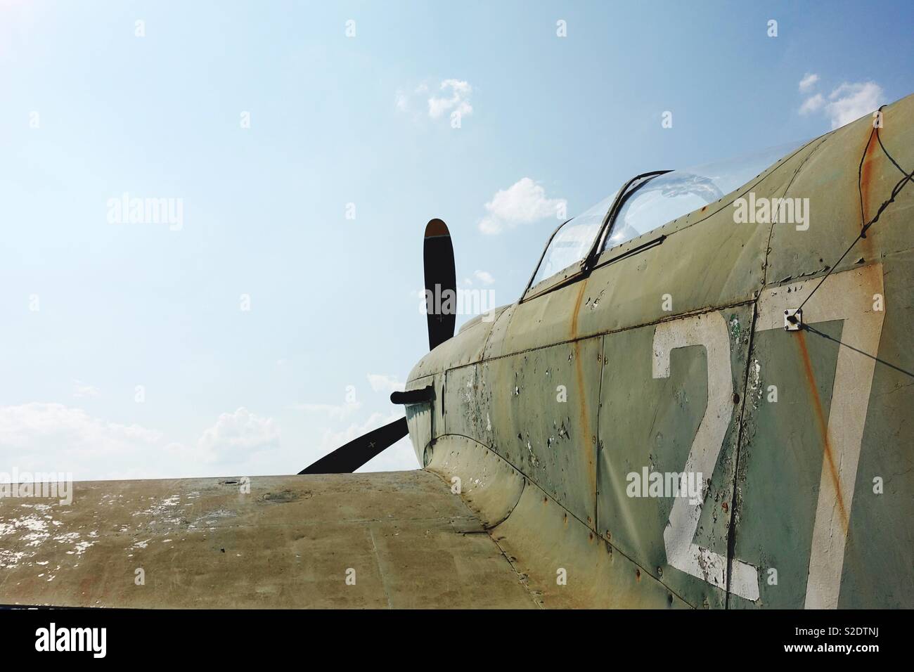 Old and rusty fighter airplane. Hiding behind his propeller, Staring ...