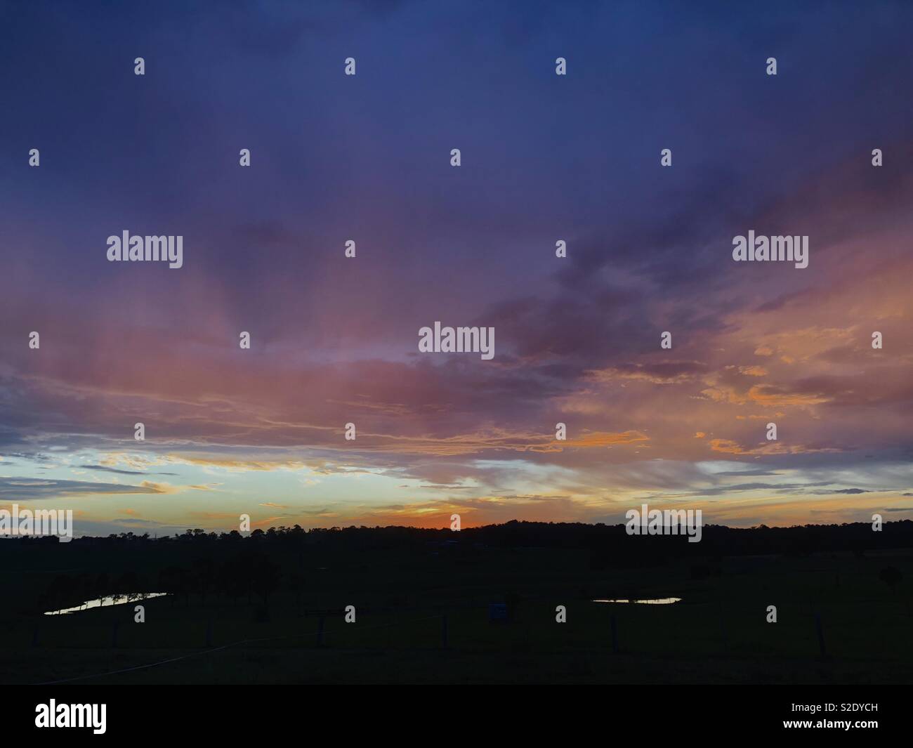 Sunset with a storm coming in Stock Photo - Alamy