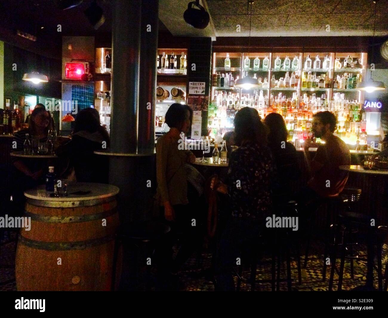 Interior of pub at night with people sitting around counter at bar and ...
