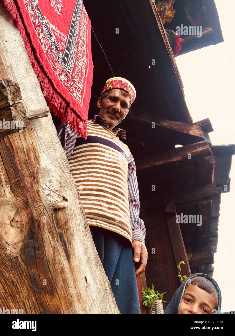 Villager standing on the porch and giving glance to his guests Stock ...