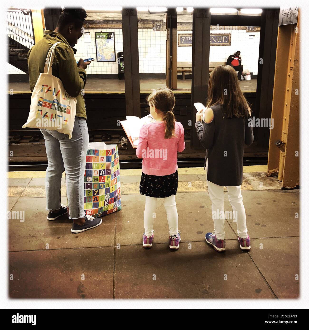 Children reading while waiting fir the subway Stock Photo - Alamy