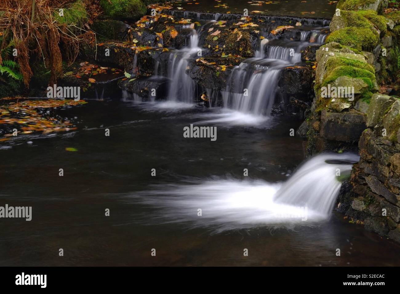 Three small waterfalls flow into a river Stock Photo - Alamy
