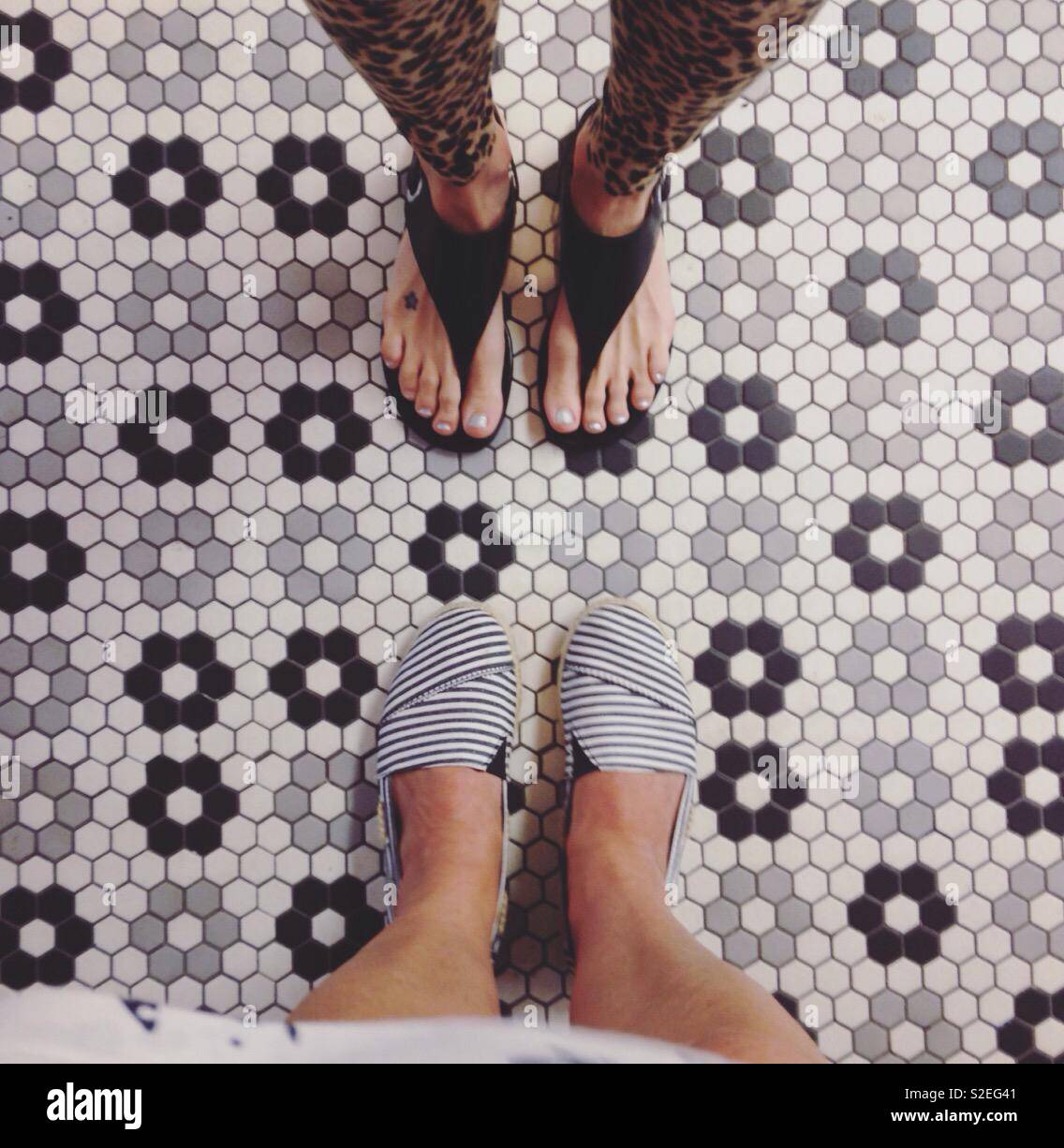 First person perspective of legs and feet, shoes on tile floor, mother ...