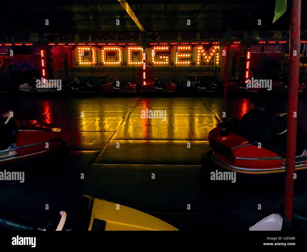 Illuminated dodgem sign reflecting on the track at Dingles vintage ...