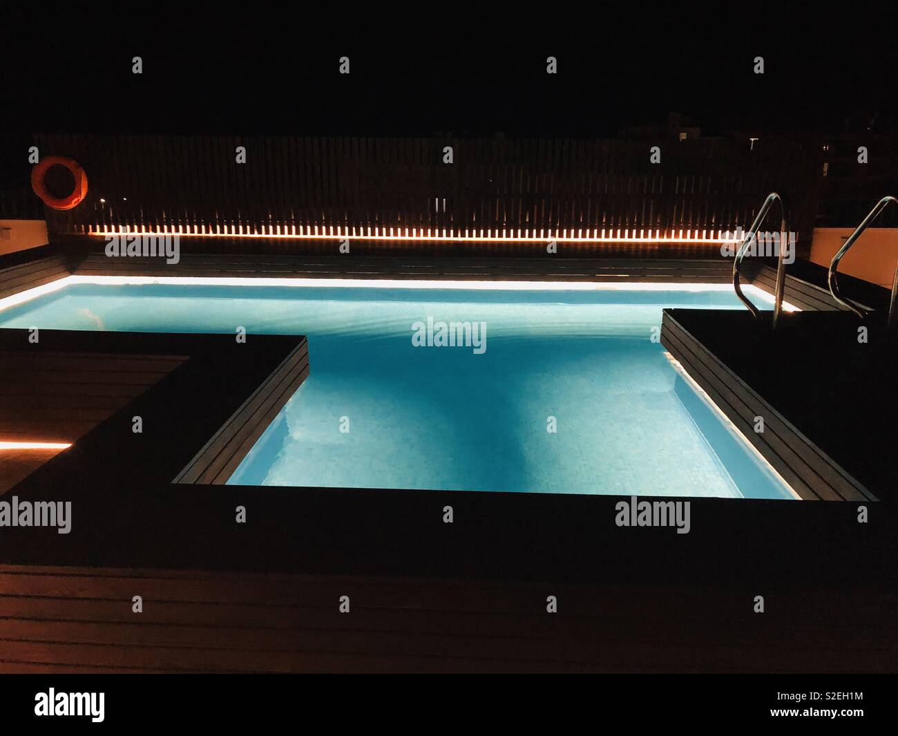 Swimming pool lit at night Stock Photo - Alamy